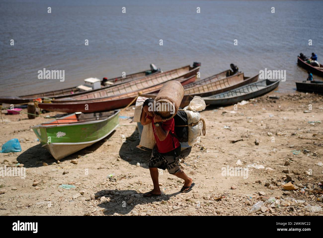 A miner carries his belongings after arriving by boat from the Bulla ...