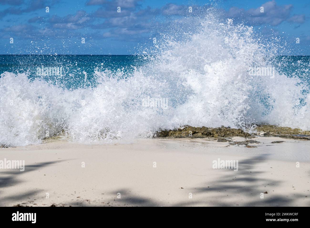 San Salvador Island Bahamas, big waves crashing onto white sand beach, almost cloudless sky ...