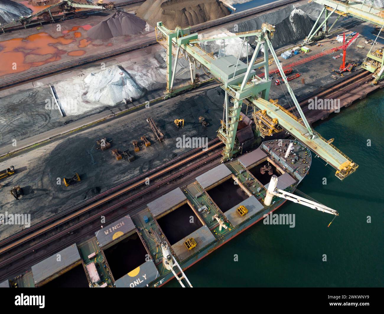 Aerial view of a large bulk carrier supplying iron-ore in a harbor ...
