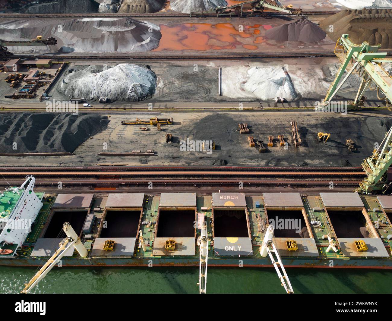 Aerial view of a large bulk carrier supplying iron-ore in a harbor ...