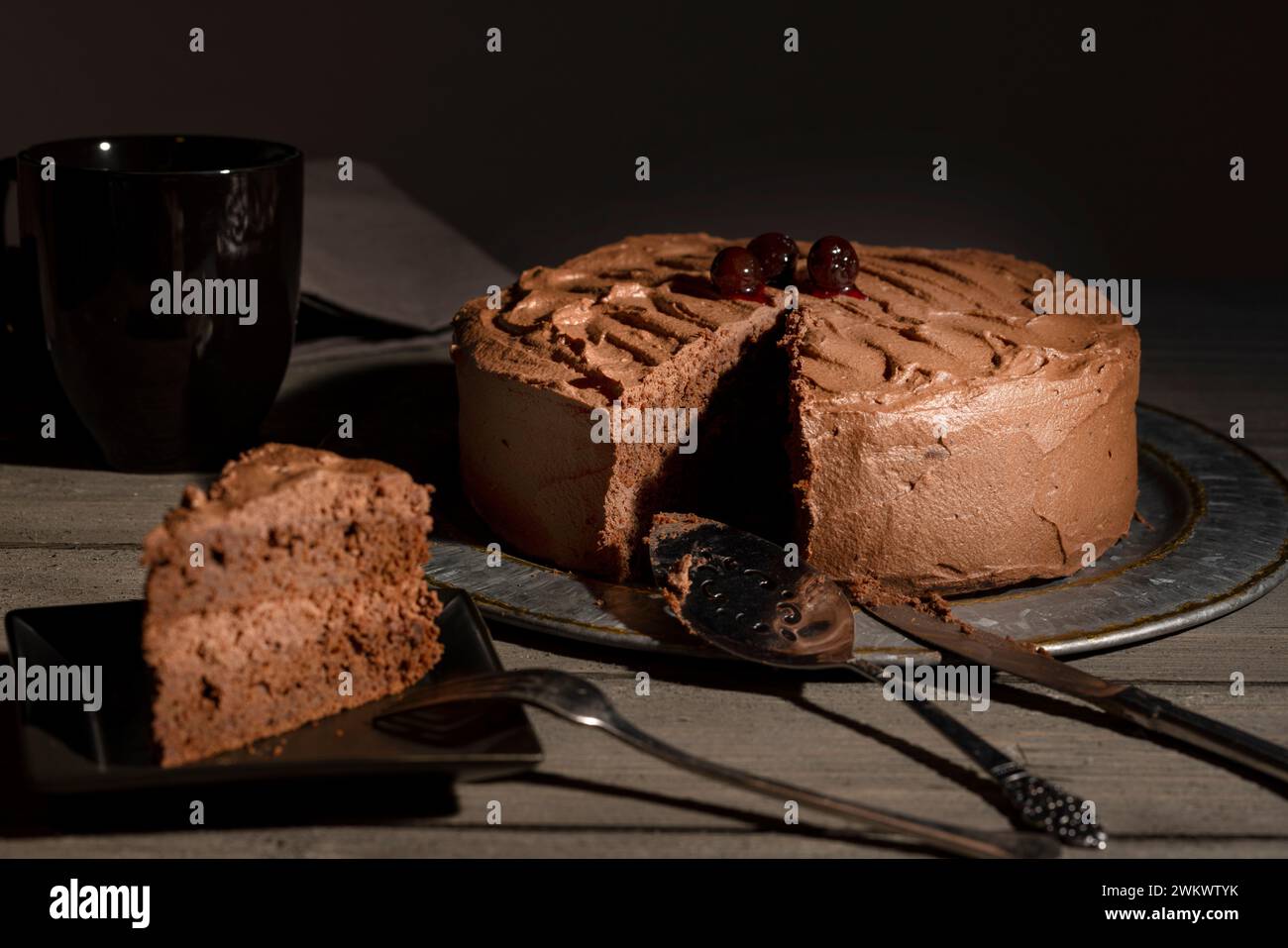 Creamy chocolate frosting and cake with cherries on top on a decorative ...