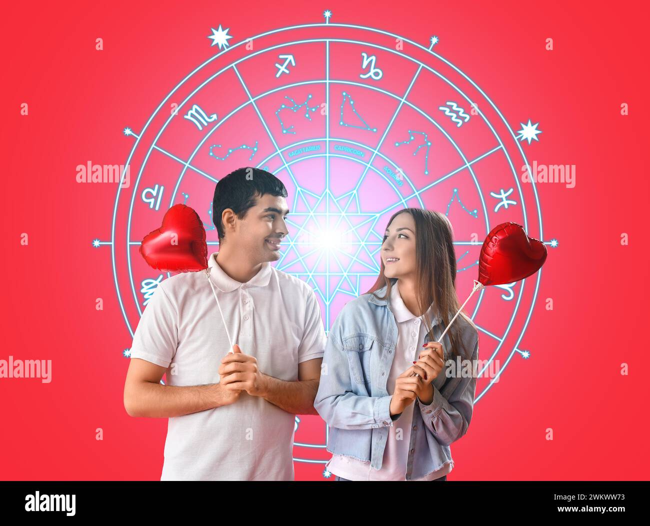 Portrait of young couple with heart-shaped balloons and drawn zodiac ...