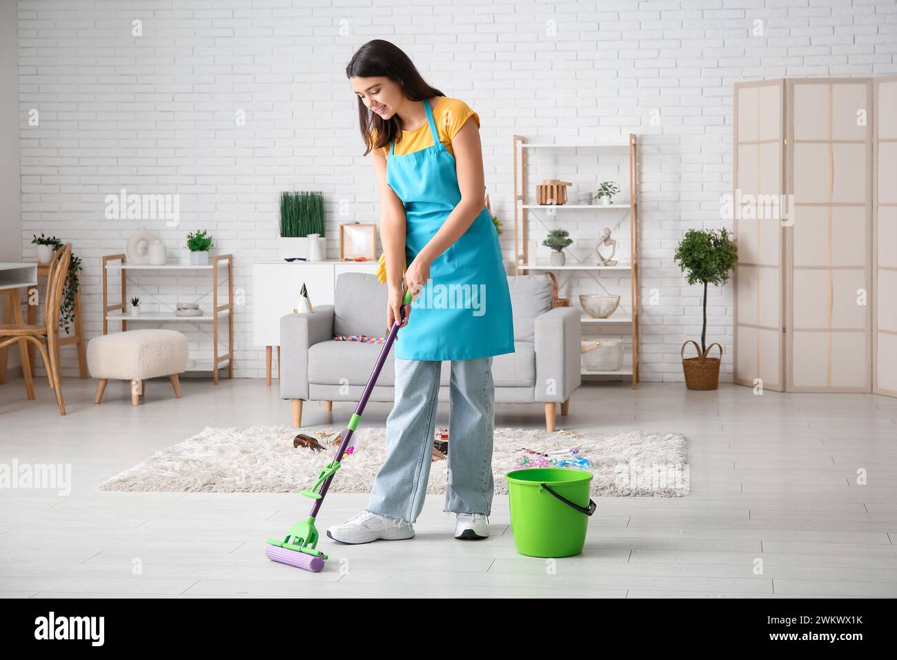 Young woman cleaning living room after party Stock Photo - Alamy