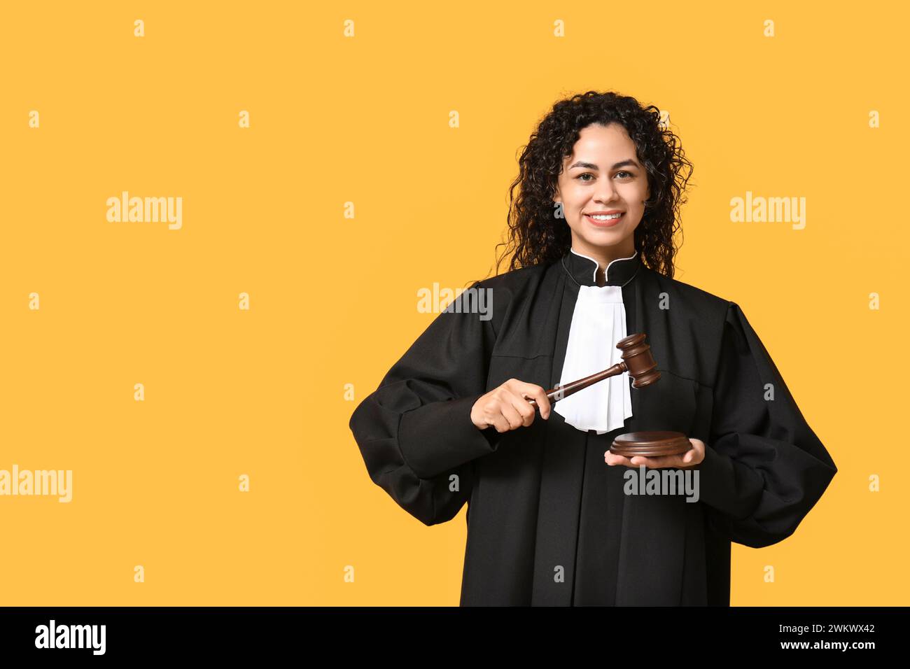 Beautiful young happy African-American female judge with gavel on ...