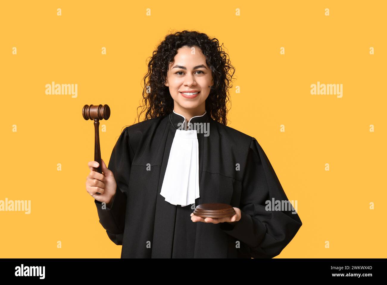 Beautiful young happy African-American female judge with gavel on ...