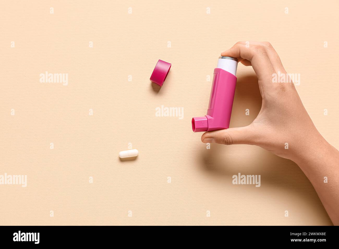 Child's hand with asthma inhaler and pill on beige background Stock ...