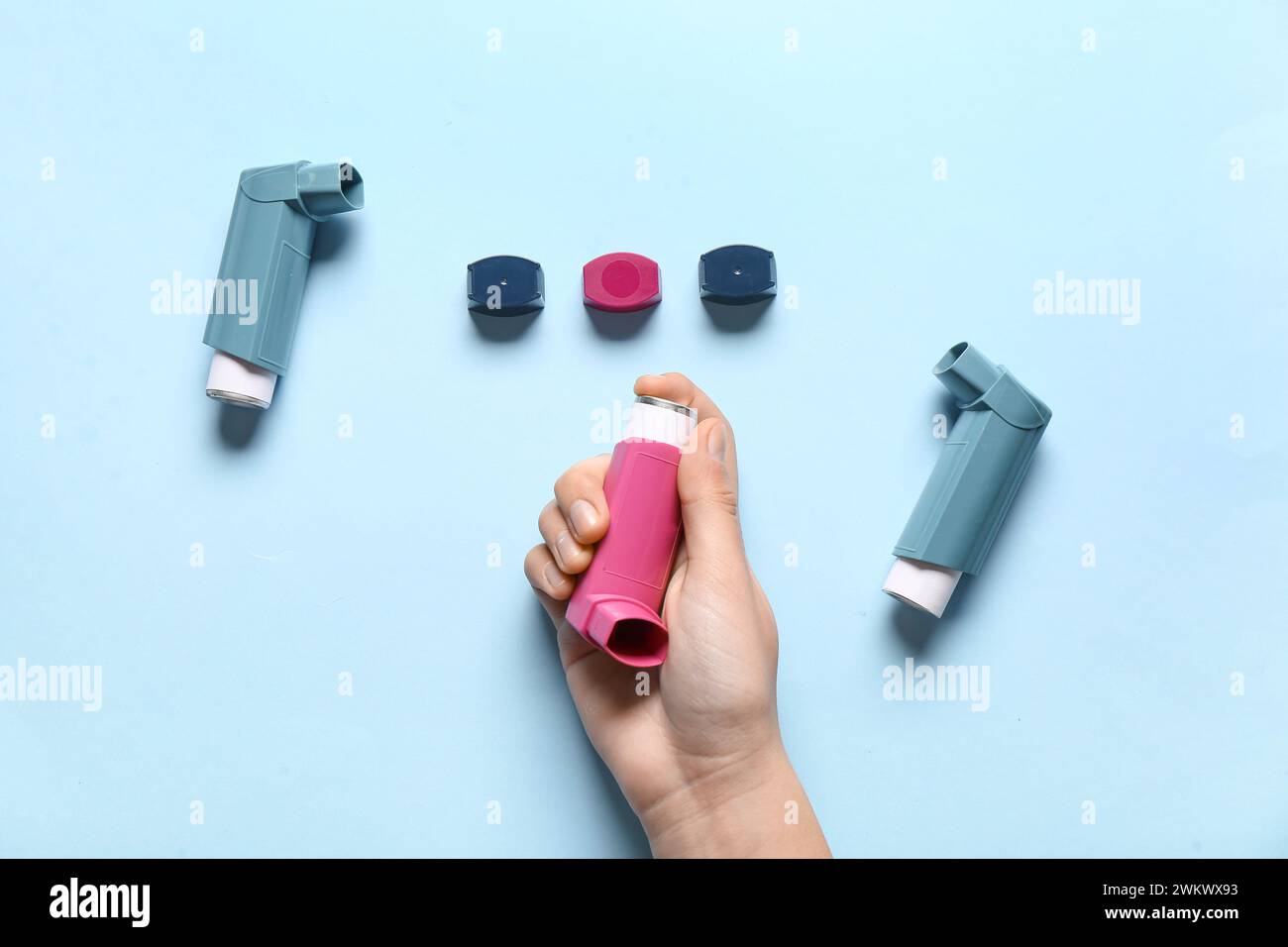 Child's hand with asthma inhalers on blue background Stock Photo - Alamy
