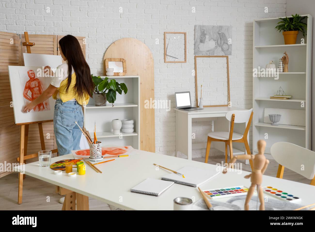 Female Asian artist drawing on canvas in workshop Stock Photo - Alamy