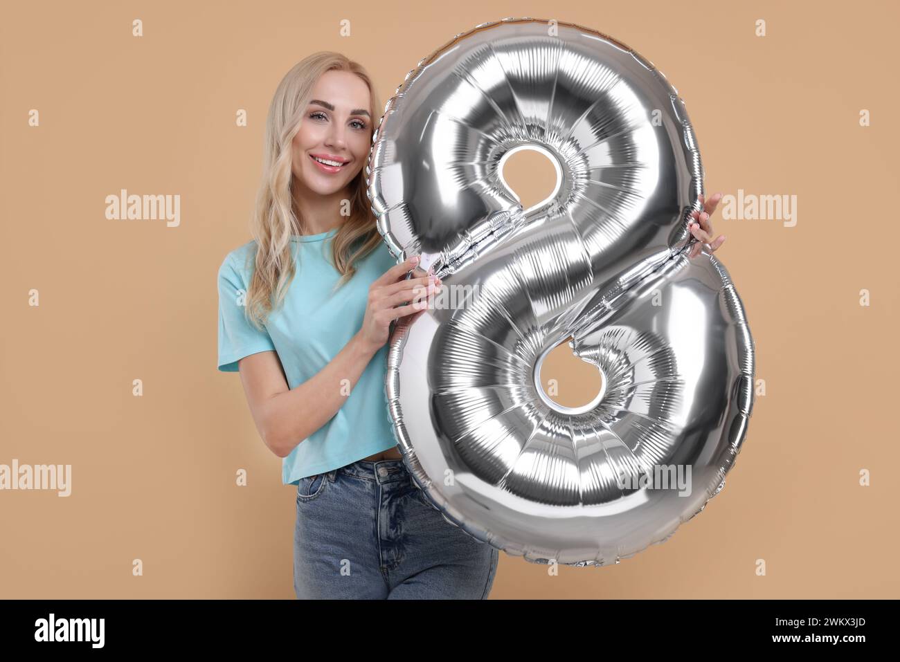 Happy Women's Day. Charming lady holding balloon in shape of number 8 ...