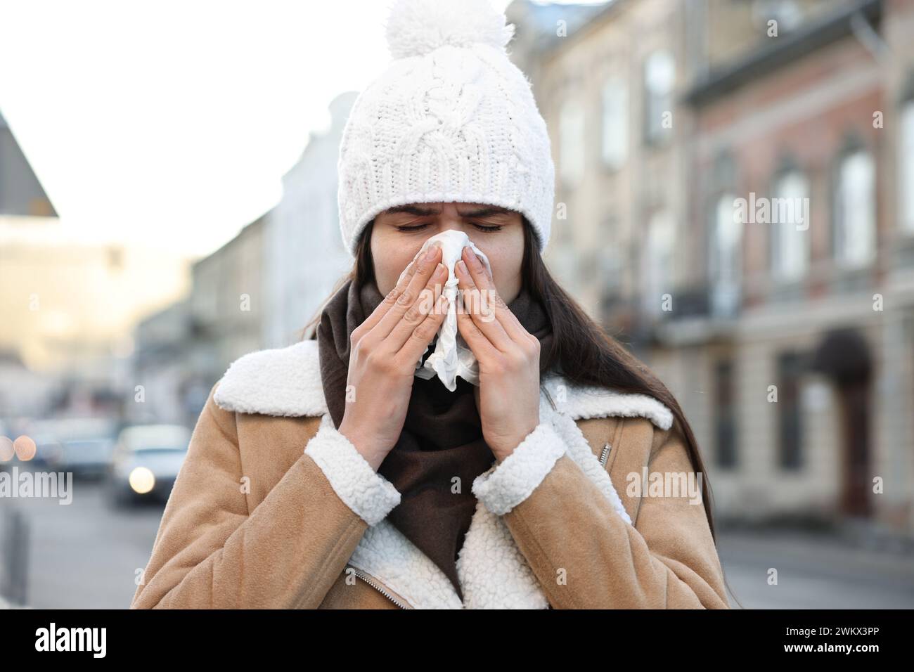 Woman with tissue blowing runny nose outdoors. Cold symptom Stock Photo ...