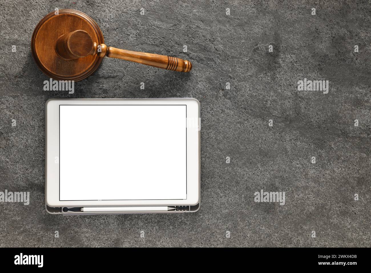 Modern tablet and gavel on gray textured table, flat lay. Space for ...