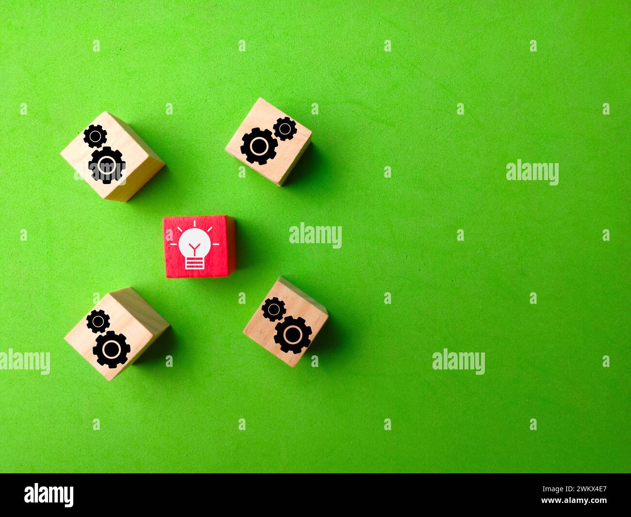 Wooden blocks with cogwheel and light bulb symbols on a green ...