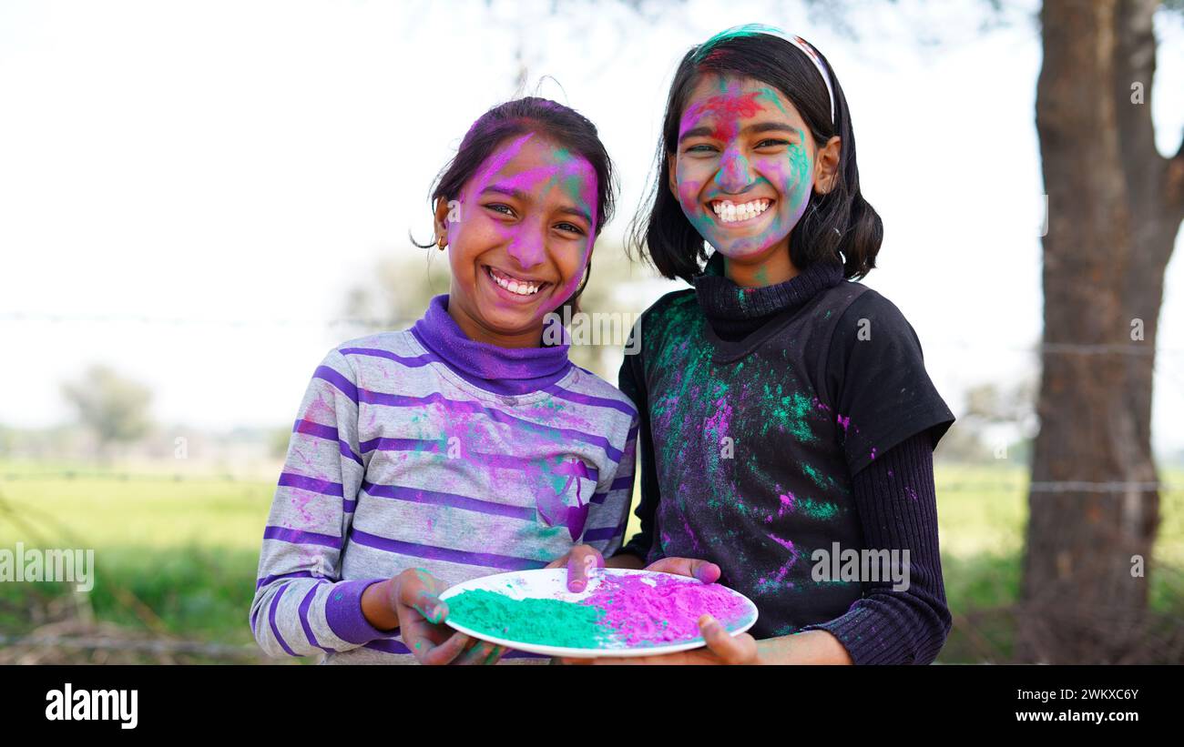Happy Indian young girls playing colours, smiling with colors on face ...