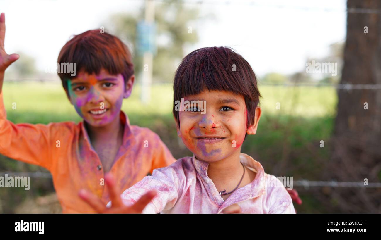 Happy Indian kids playing colours, smiling with colors on face or asian ...