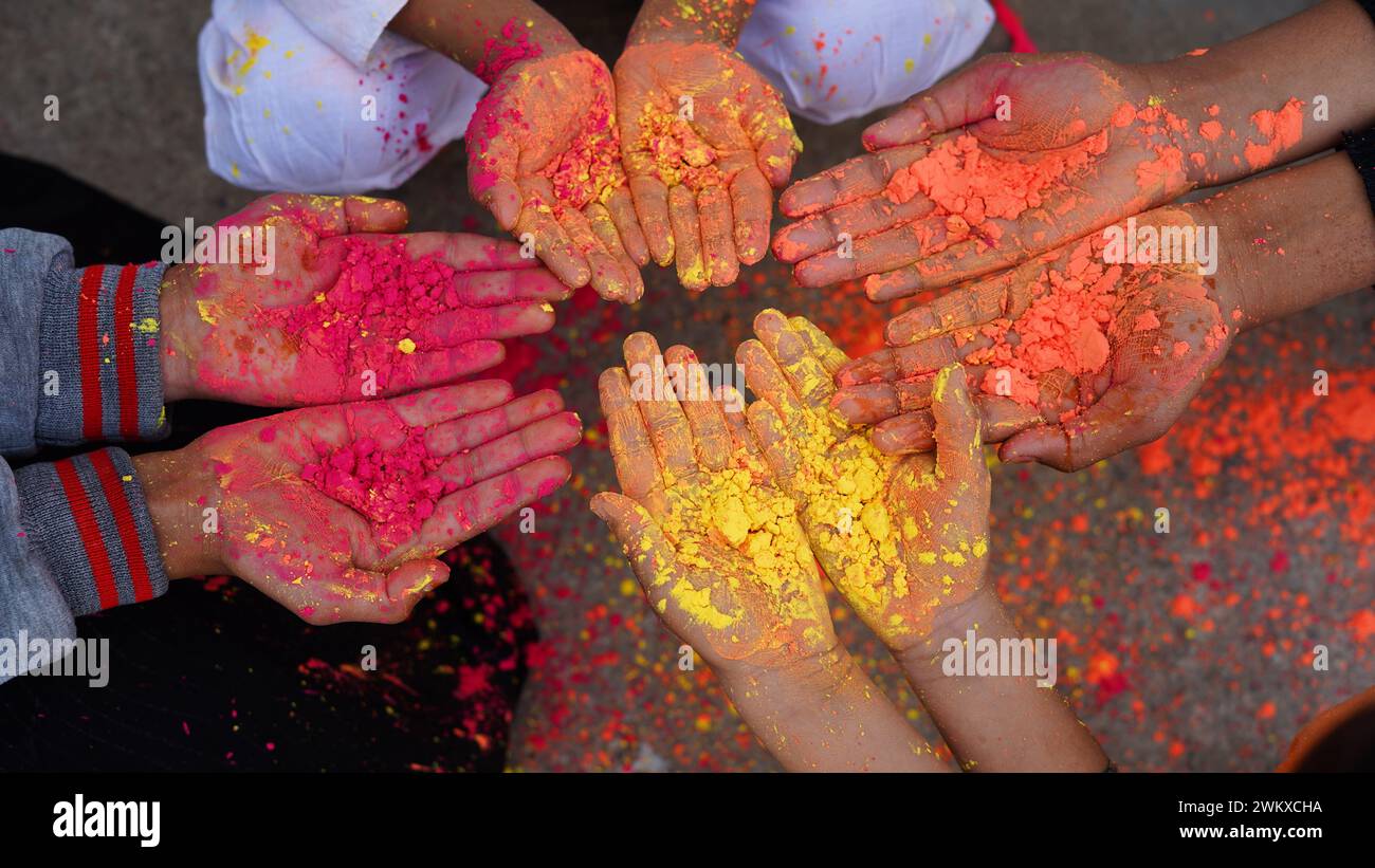 Indian kids playing with colours or asian children celebrating holi ...