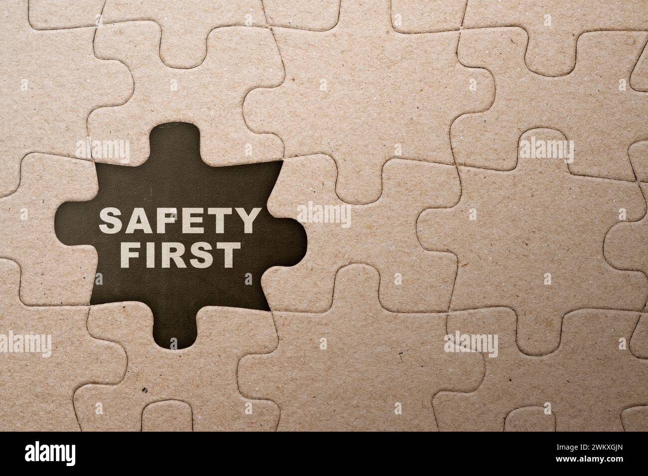Piece of missing jigsaw puzzle with 'safety first' text on a black ...