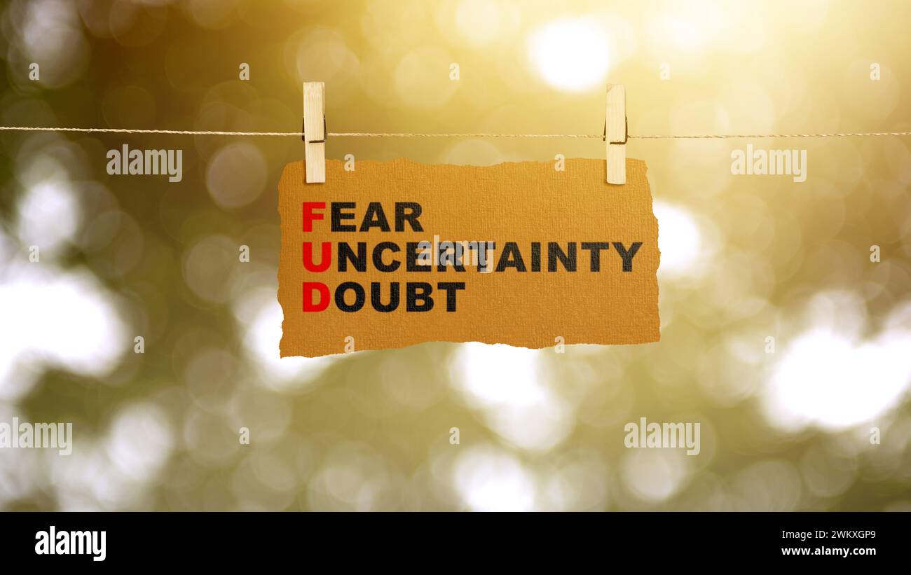 Paper hanging on the rope with 'Fear Uncertainty Doubt' text. Business ...