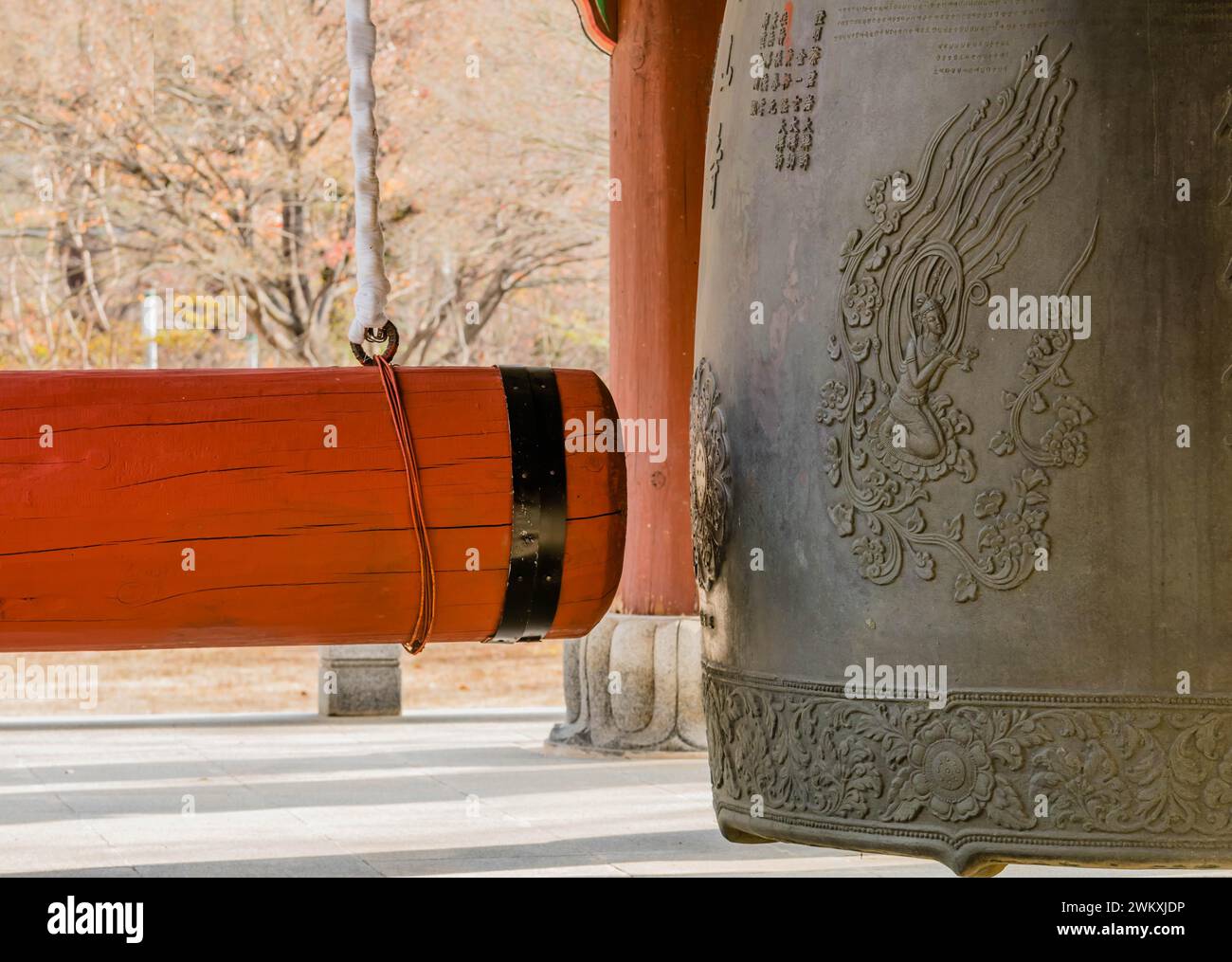 Large red wooden gong on linen wrapped chain hanging next to ...