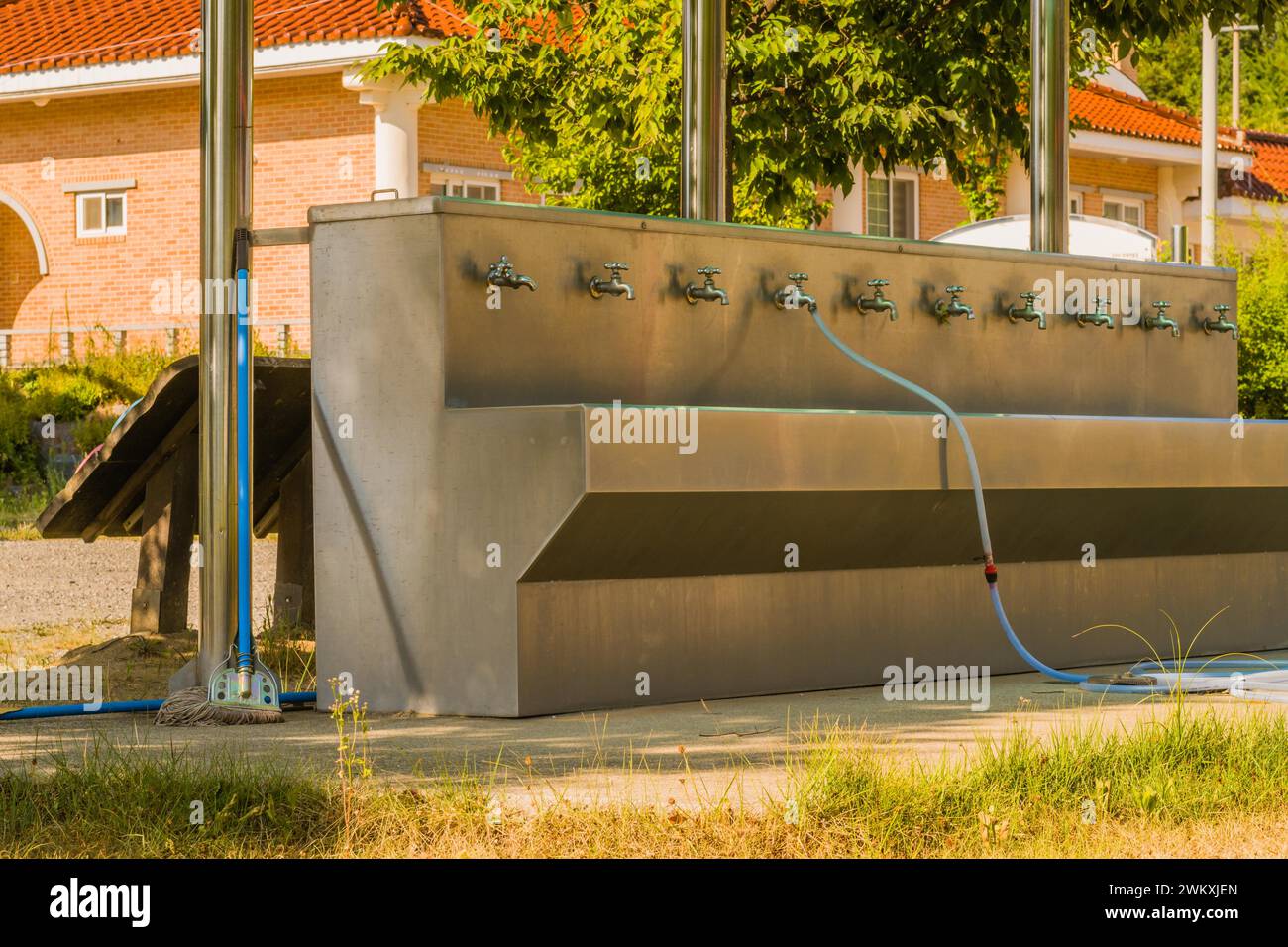 Multifaceted public washing sink and water fountain with hose attached ...