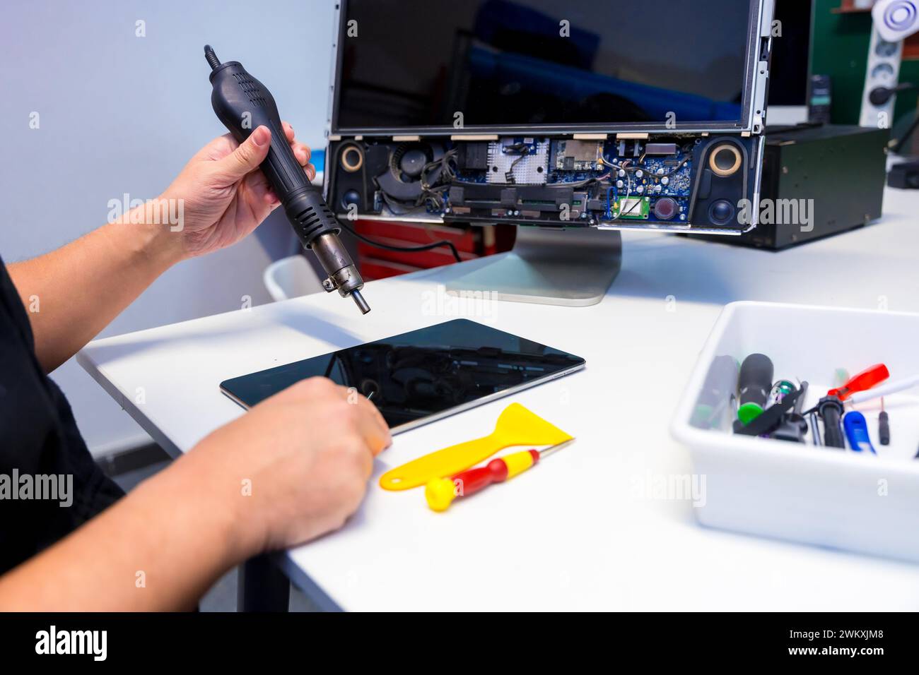 Side view of an unrecognizable technician fixing a computer component ...