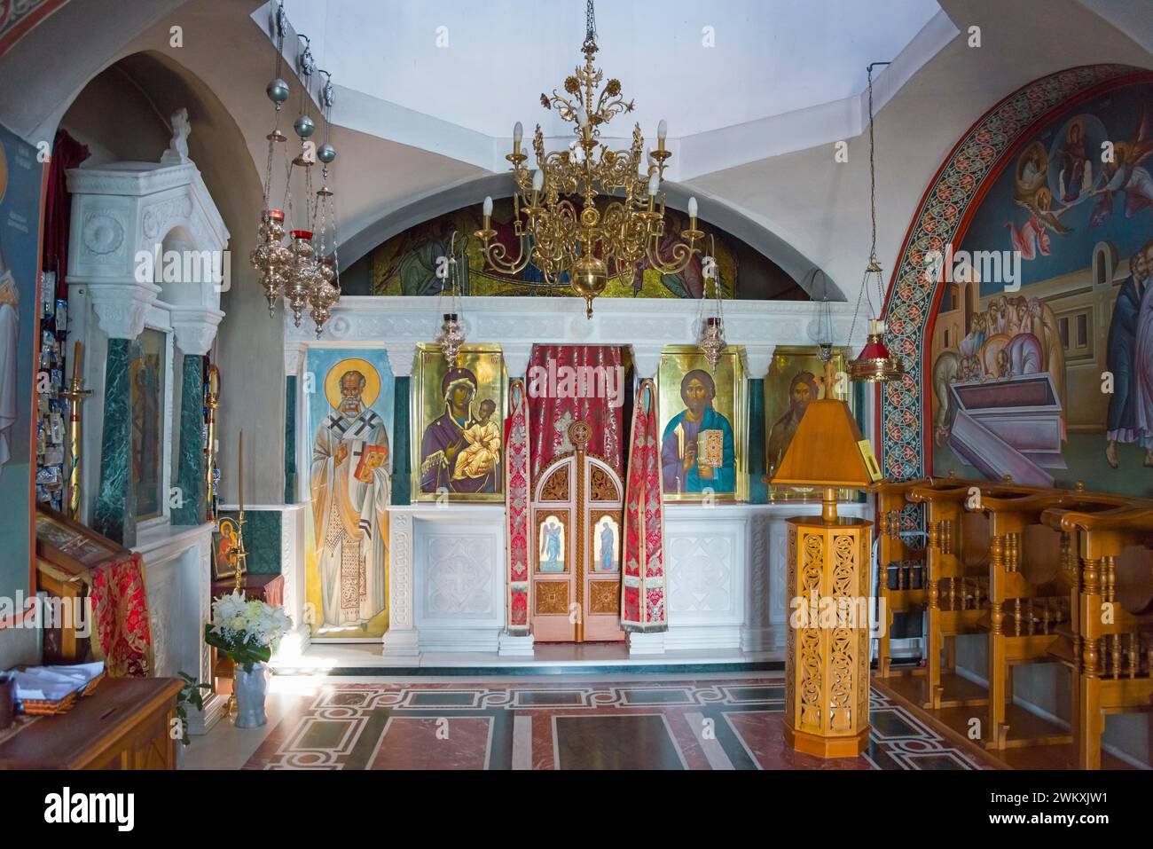 Interior view of a small church with richly decorated iconostasis and ...