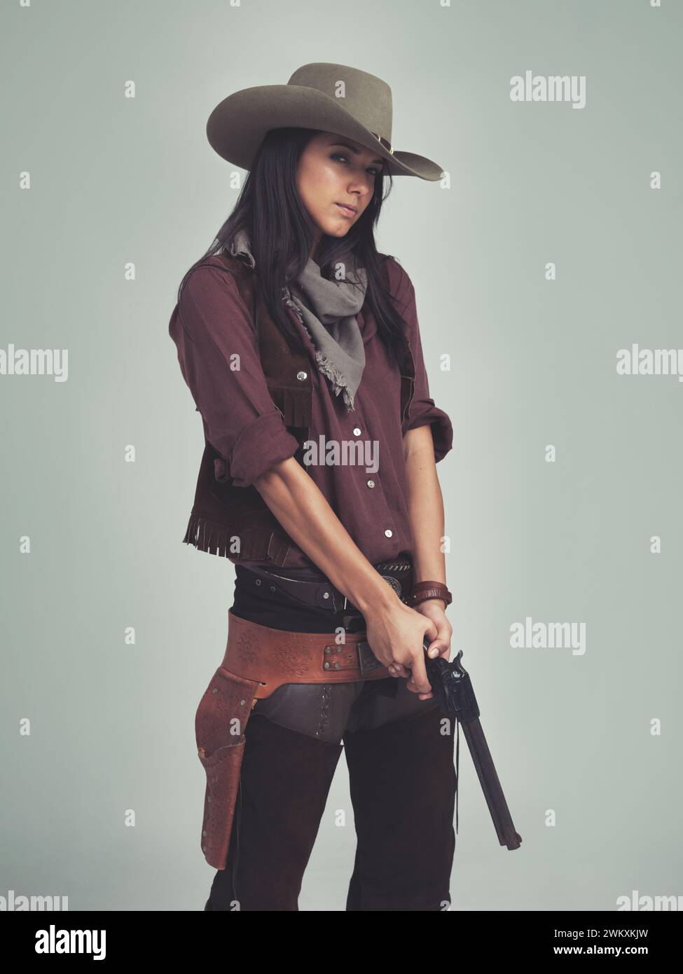 Woman, fashion and cowboy clothes with gun in studio, western character ...