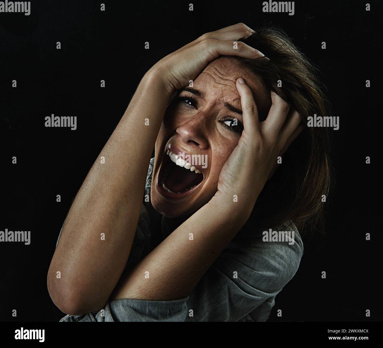 Portrait, horror and fear with woman screaming in studio on black background for reaction to ...