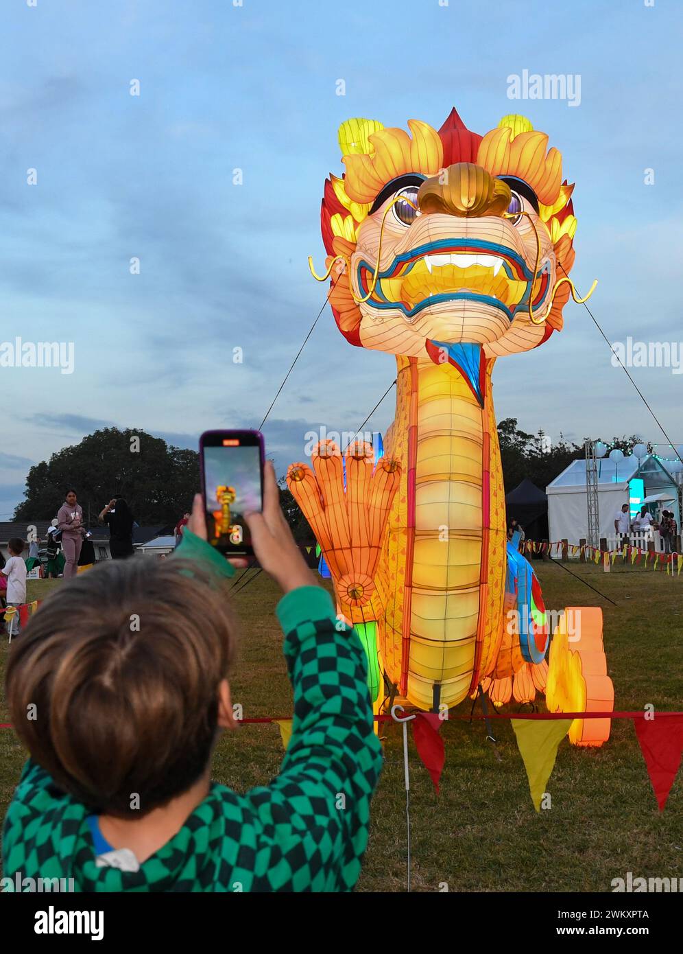 Auckland, New Zealand. 22nd Feb, 2024. A boy takes photos of a dragon ...