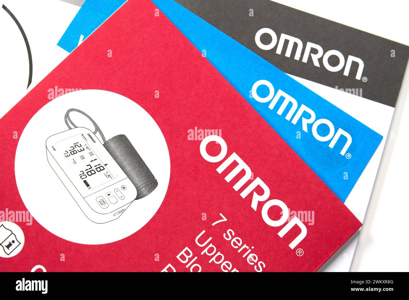Omron blood pressure monitor, logo and documentation over white ...