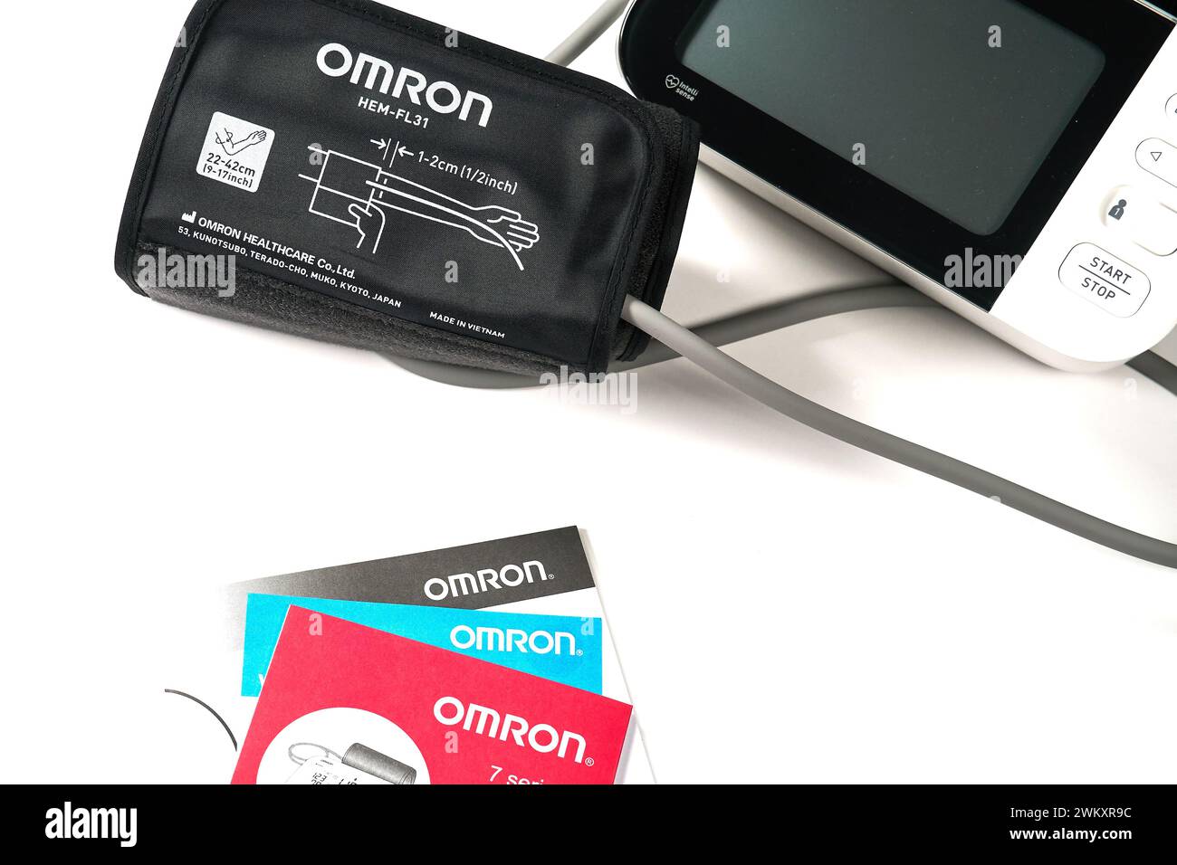 Omron blood pressure monitor, logo and documentation over white ...