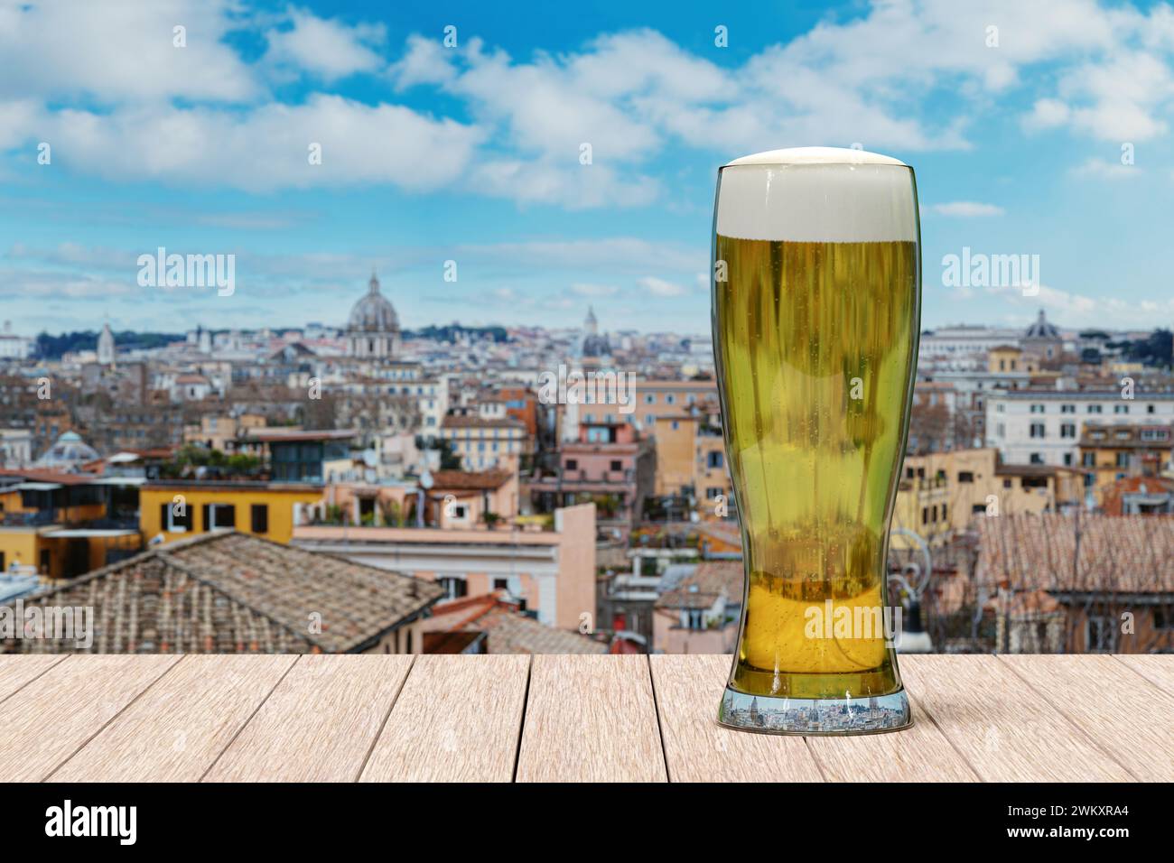 Glass of light beer on the table against view of Rome with a blue sky ...