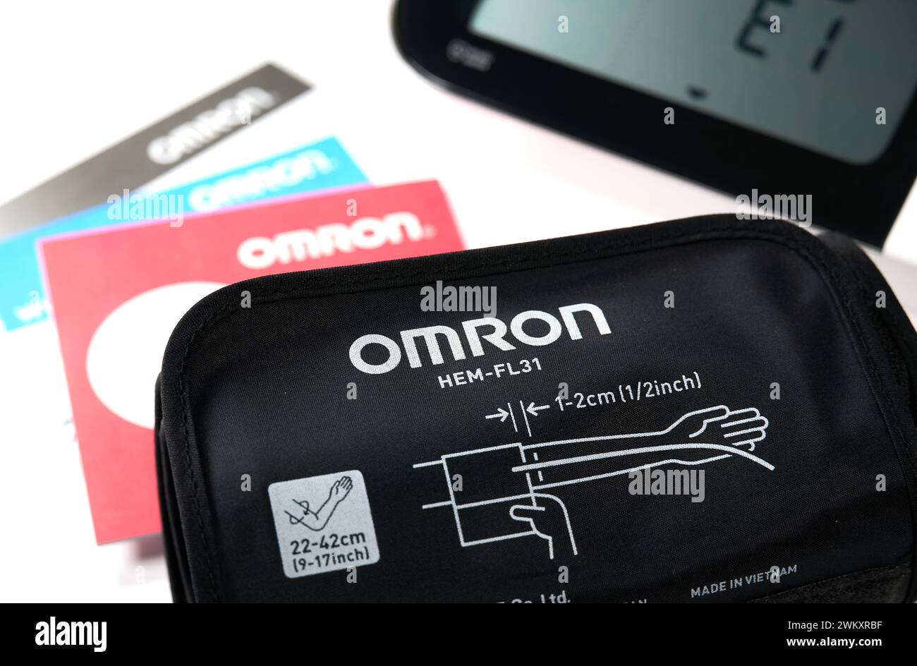 Omron blood pressure monitor, logo and documentation over white ...