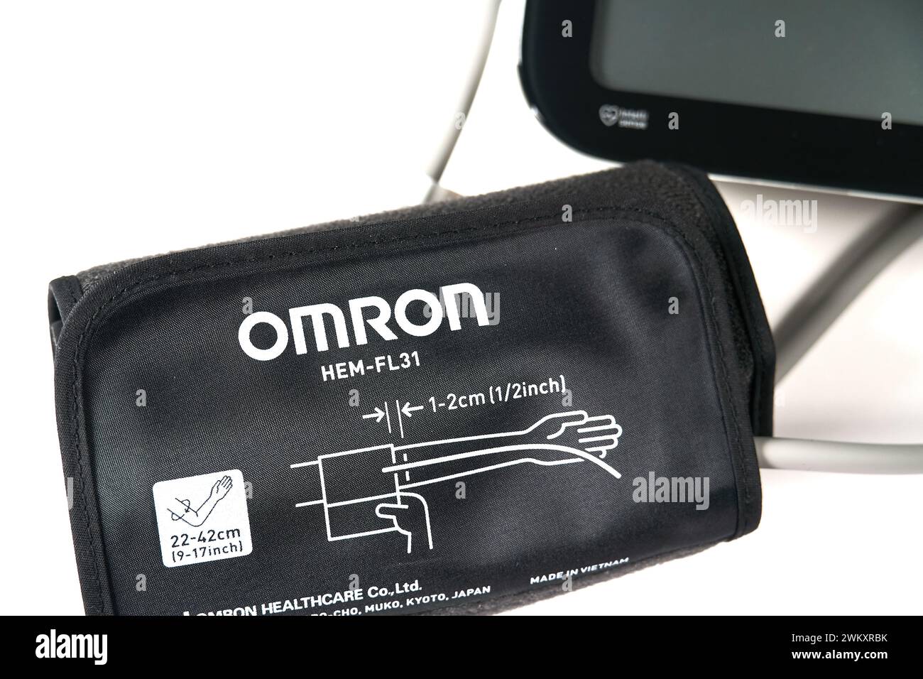 Omron blood pressure monitor, logo and documentation over white ...