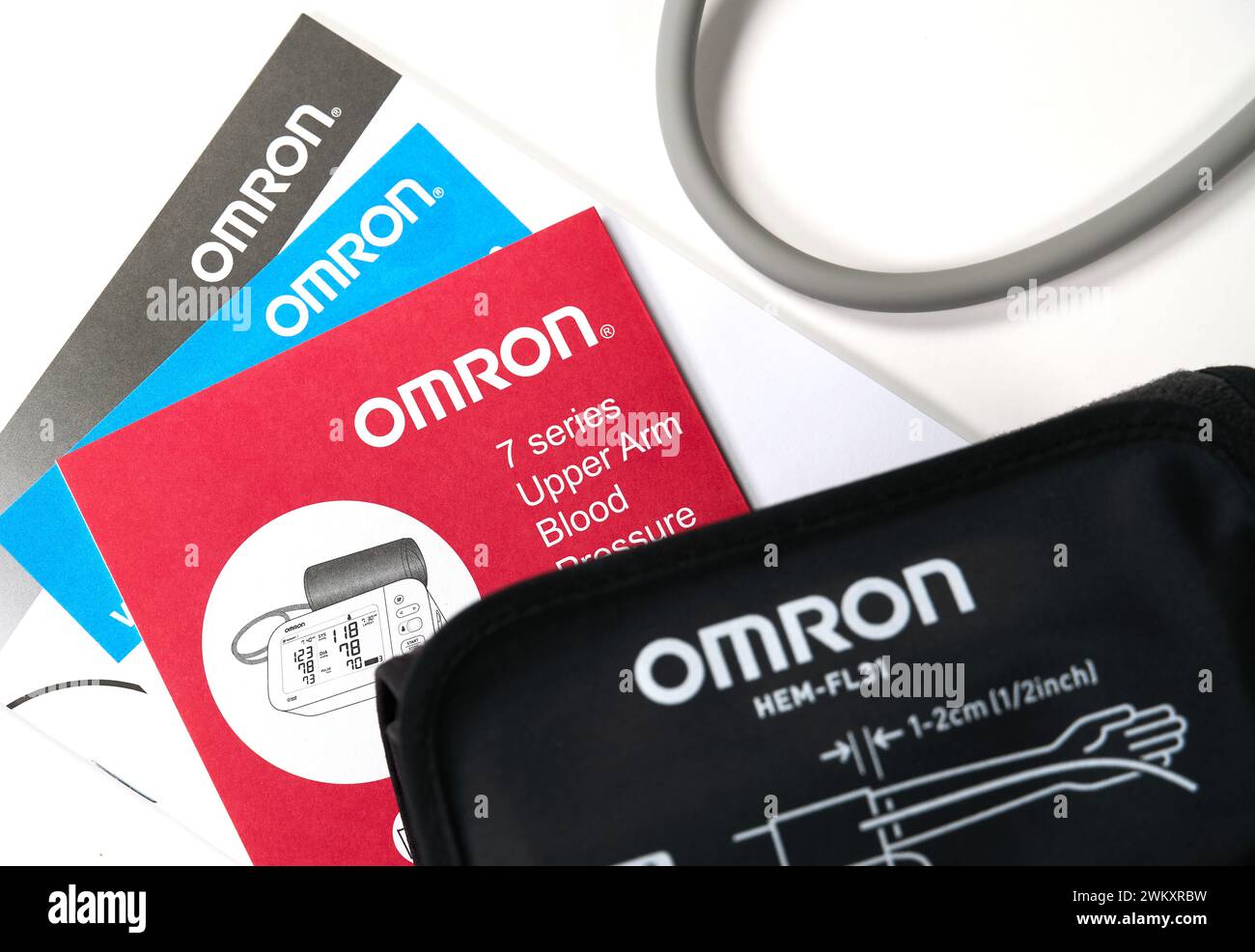 Omron blood pressure monitor, logo and documentation over white ...