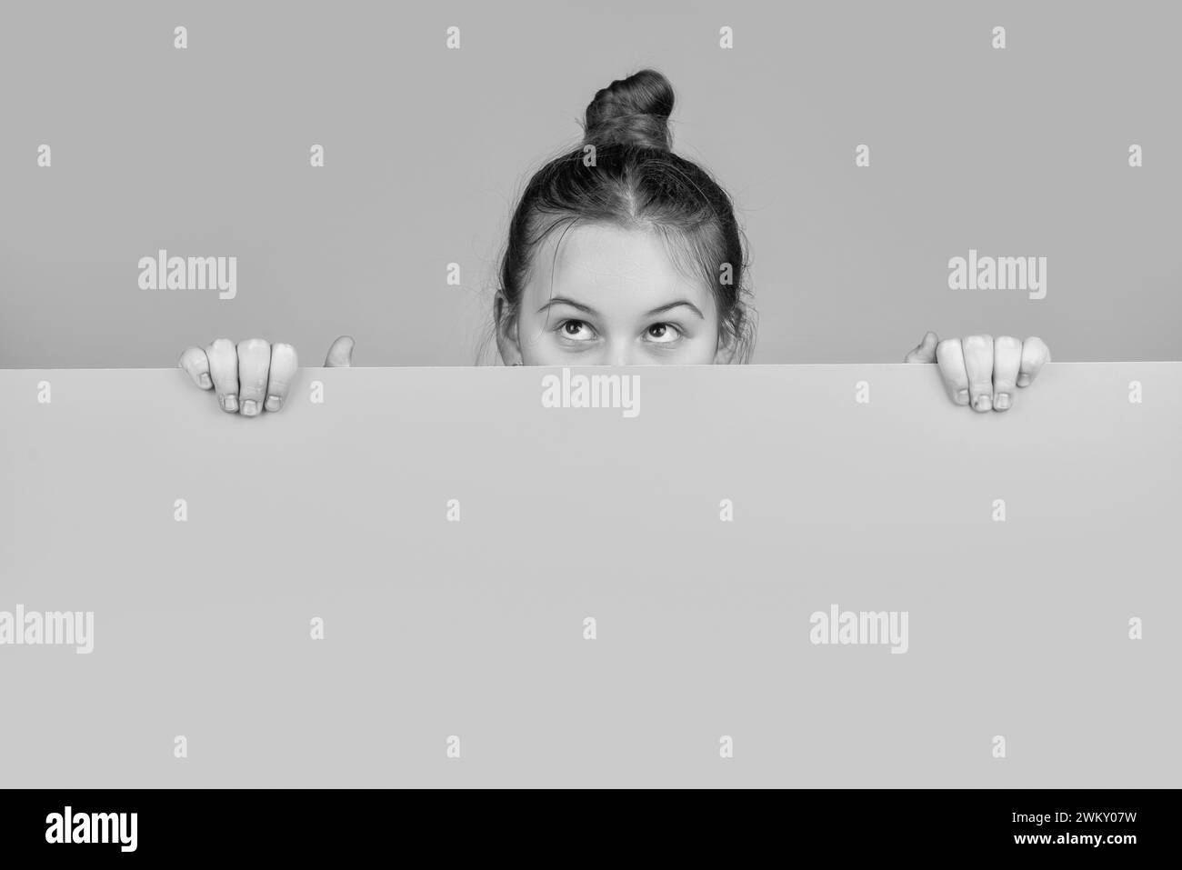 girl hiding behind yellow paper with copy space for advertisement Stock ...