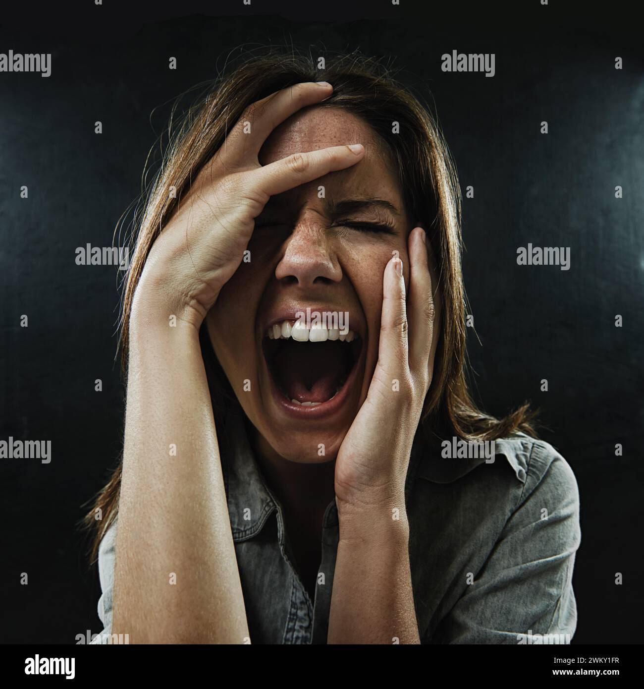 Face, stress and horror with woman screaming in studio on black ...