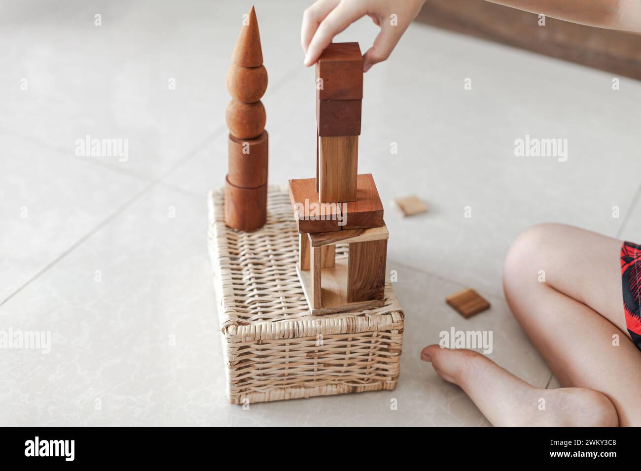 A child building with wooden blocks on the floor Stock Photo - Alamy