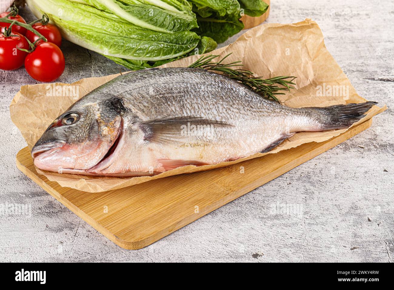 Raw dorada fish served rosemary for cooking Stock Photo - Alamy