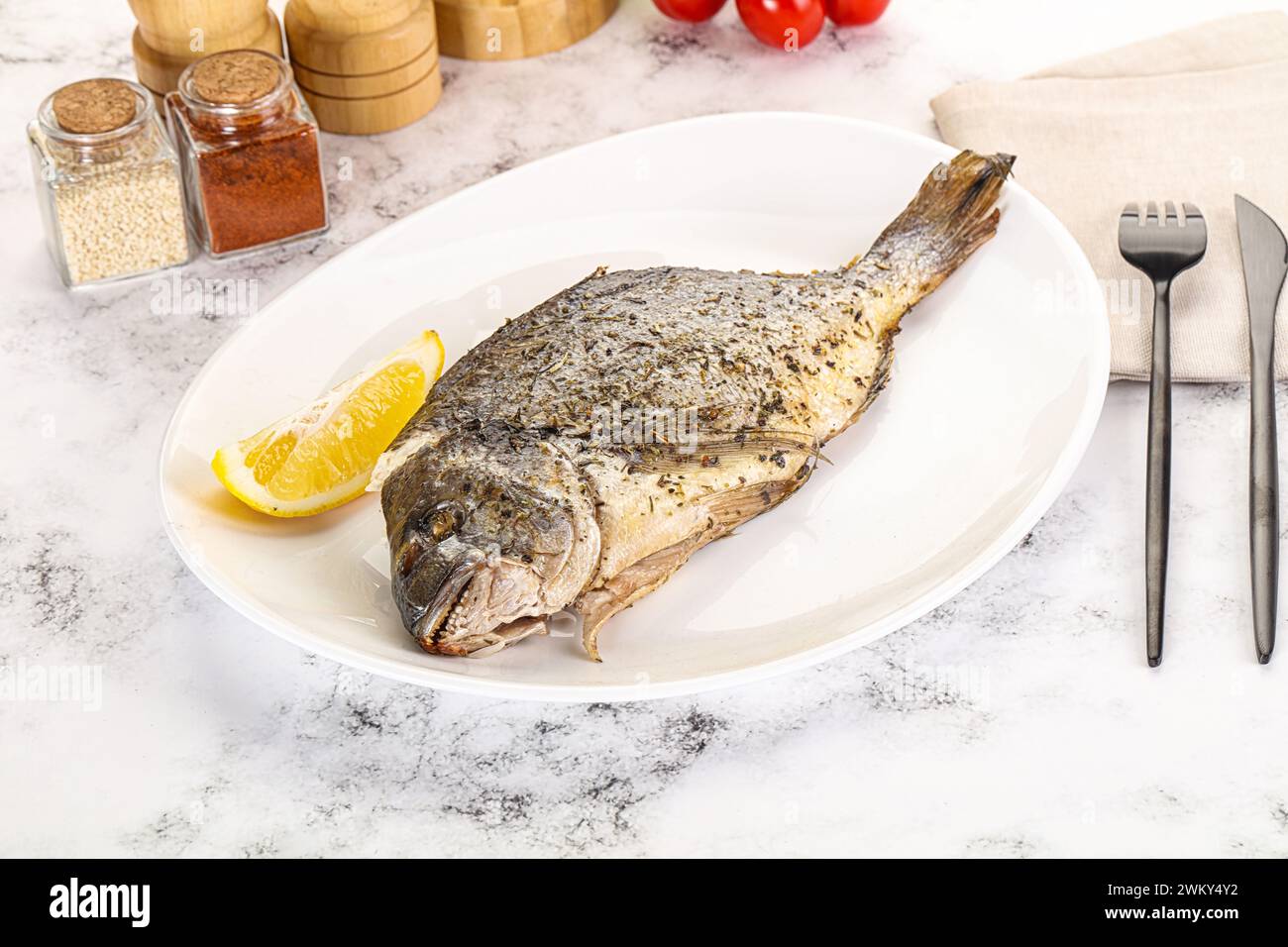 Baked Dorado fish served lemon slice Stock Photo - Alamy