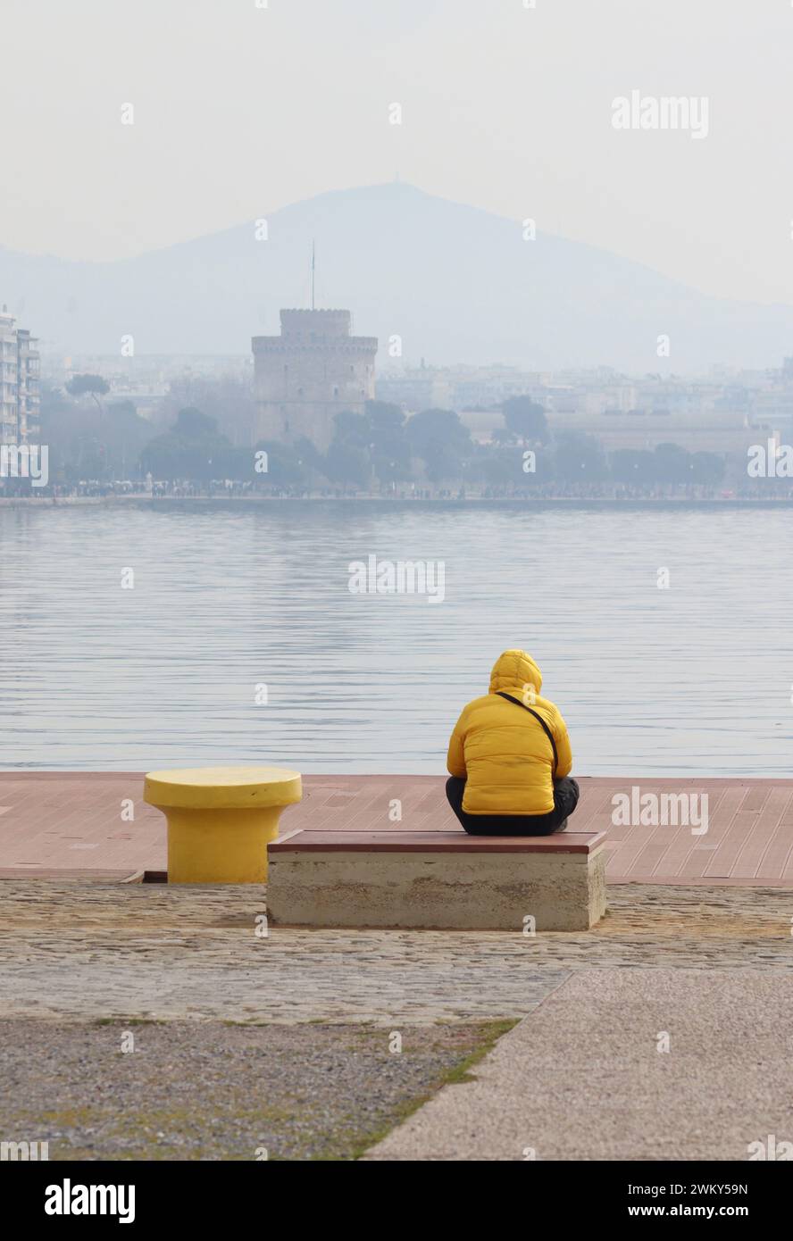 Sitting with serenity. Back view perspective. Man in the yellow jacket ...