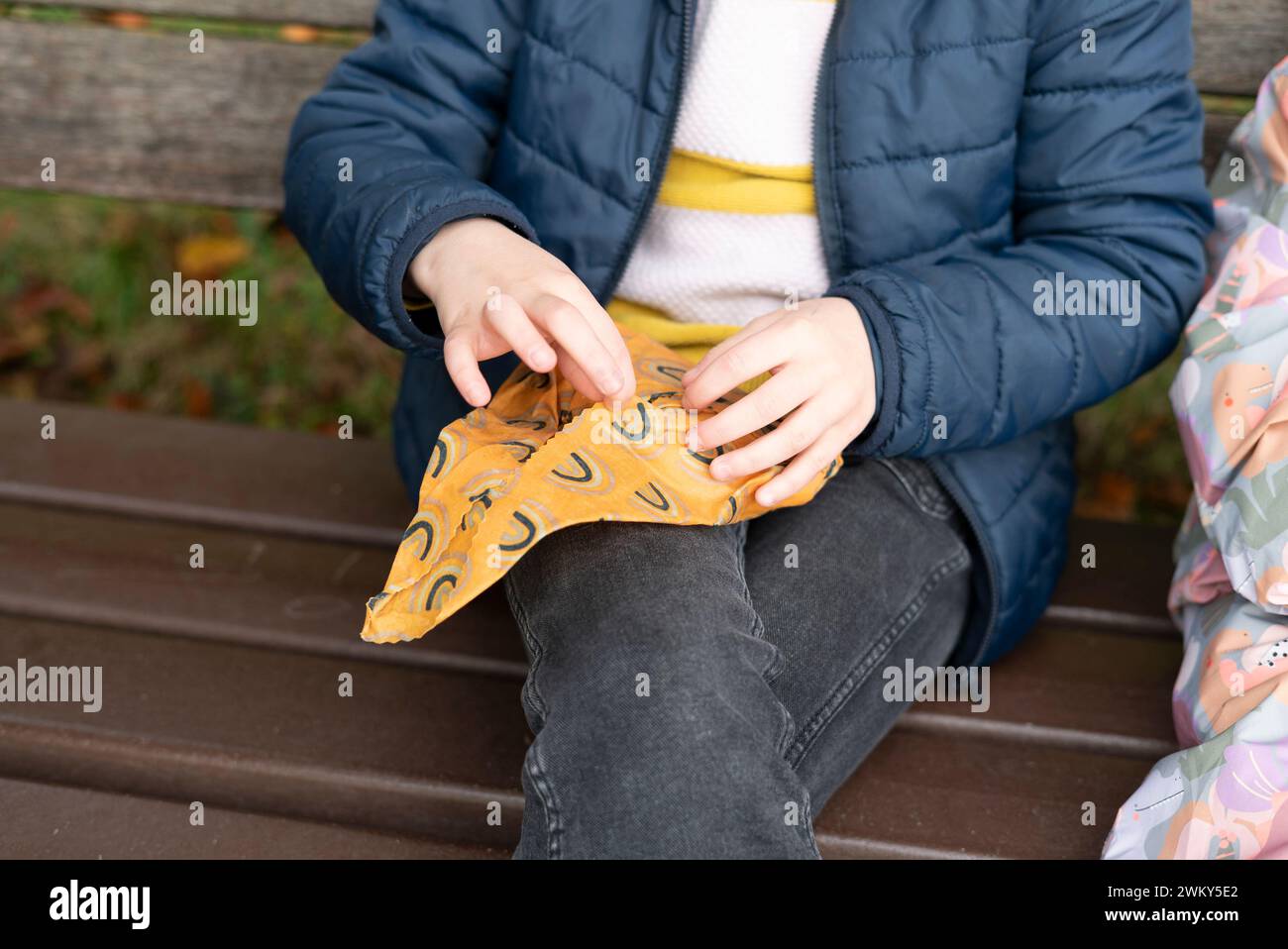 Little girl sitting on a bench in the park and holding a wallet Stock ...