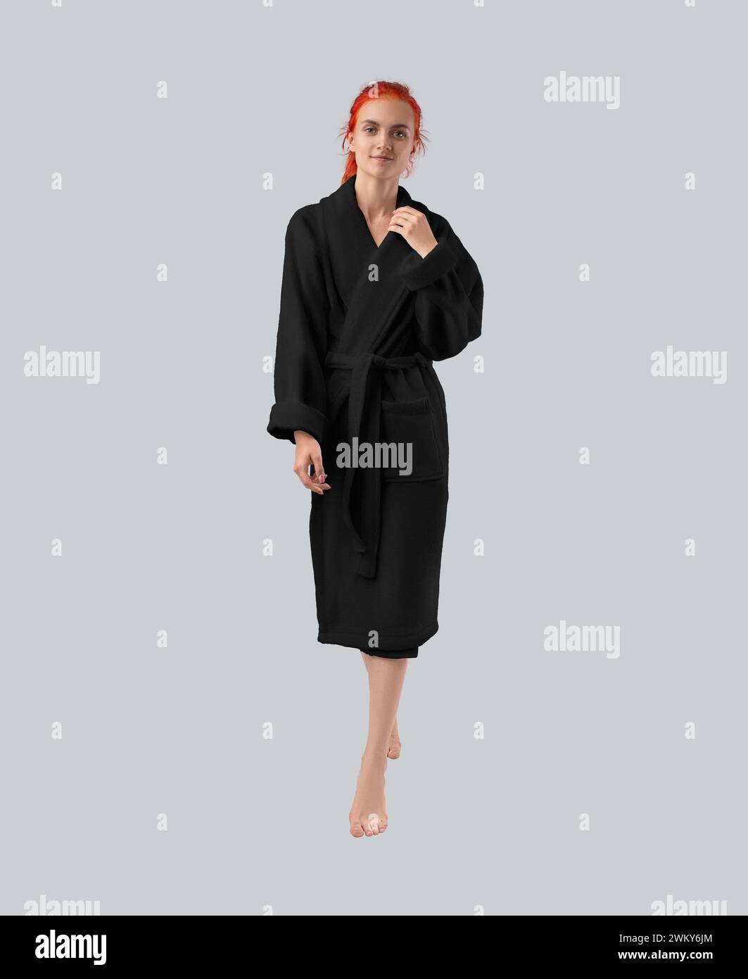 Mockup of a black terry bathrobe with a belt on a full-length red ...