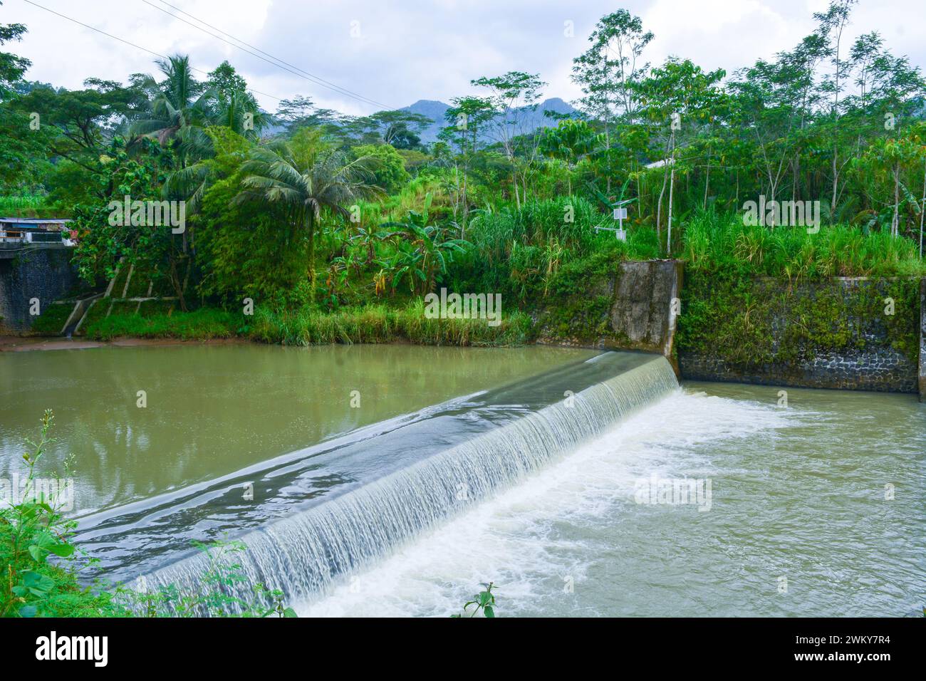 A fast-flowing stream and dramatic lenticular clouds against a dark sky ...