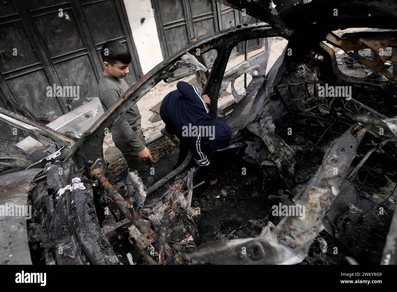 Children gather around a car destroyed in an Israeli drone strike in ...
