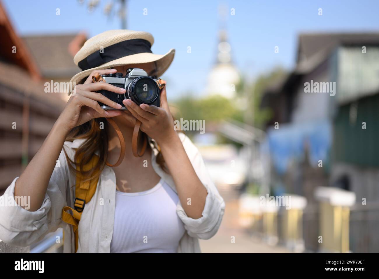 Female travel blogger taking photos with her camera of local city ...