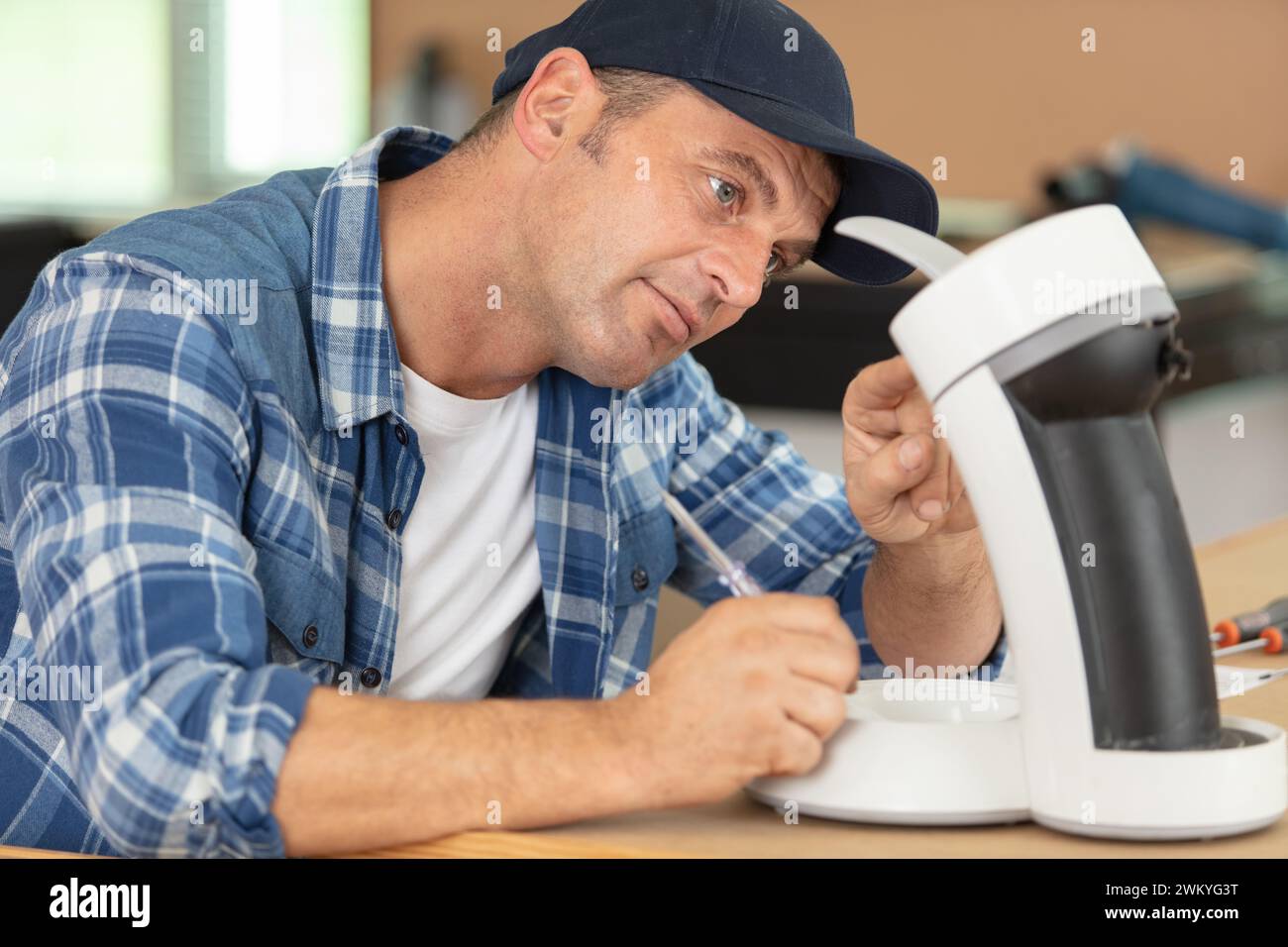 serious man repairing broken coffee machine Stock Photo - Alamy