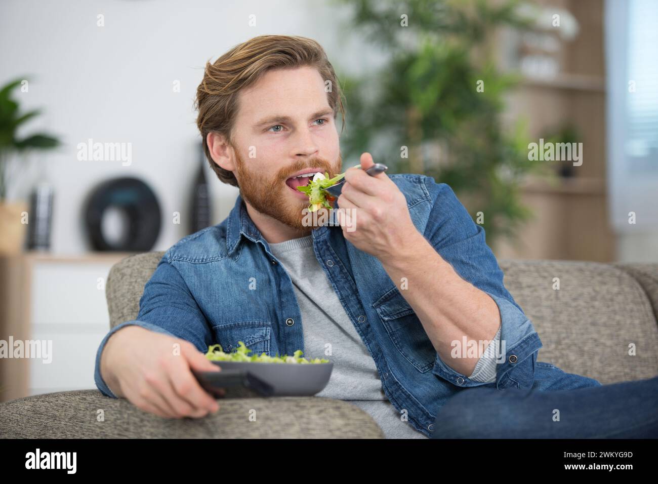 Attractive man eating salad sitting hi-res stock photography and images ...
