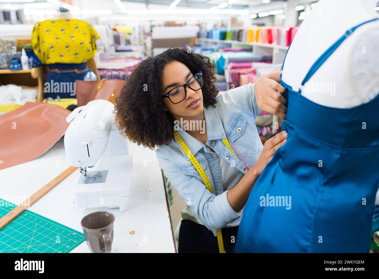 young designer fitting the dress on the mannequin Stock Photo - Alamy