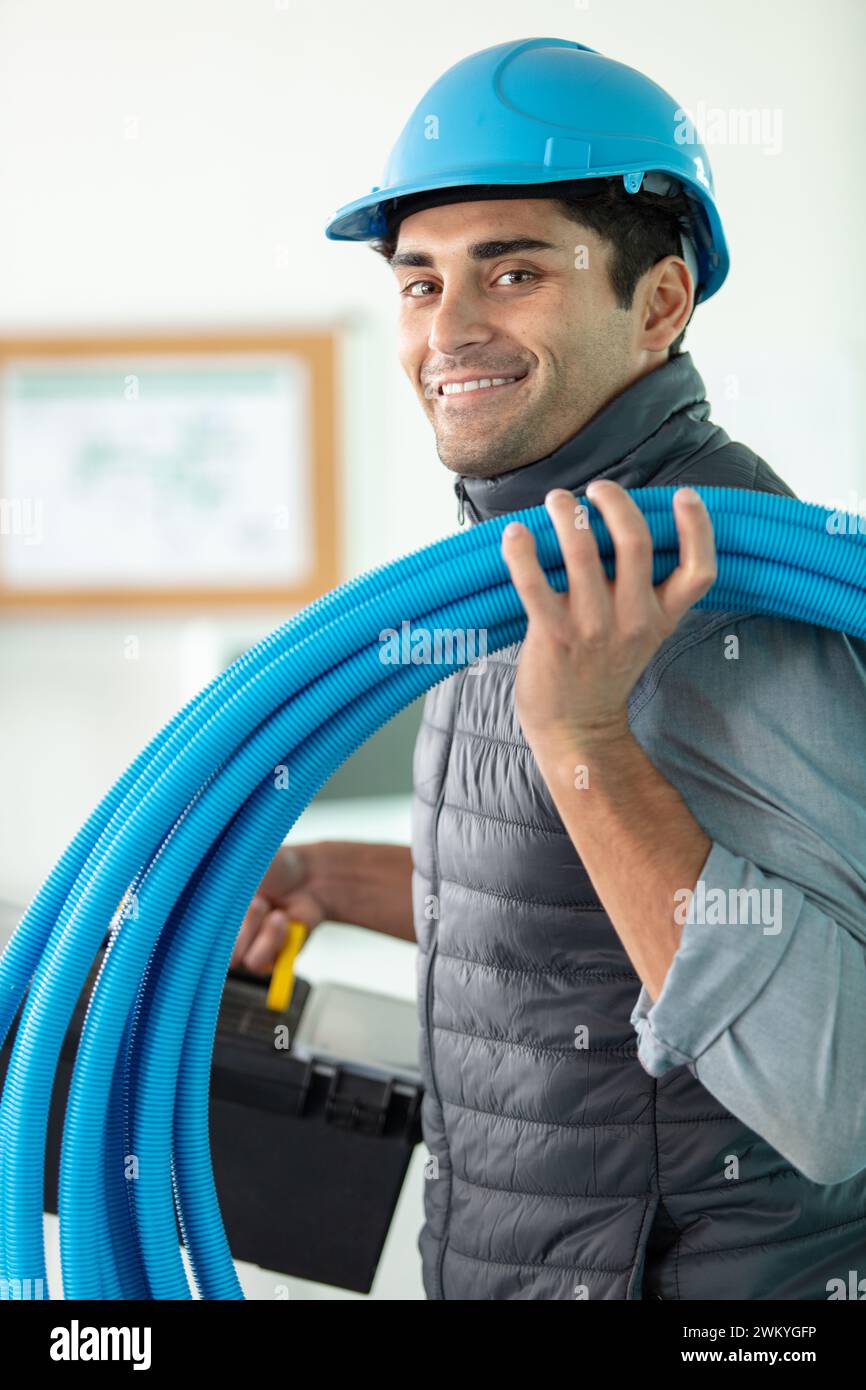male builder holding a hose pipe insulation Stock Photo - Alamy