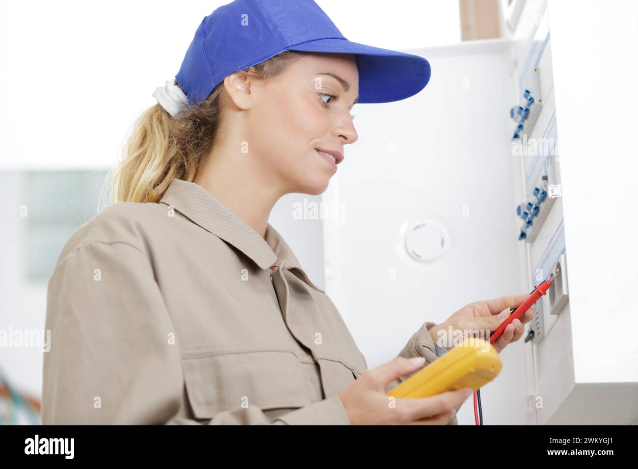 female electrician using multimeter on circuit breaker cabinet Stock ...